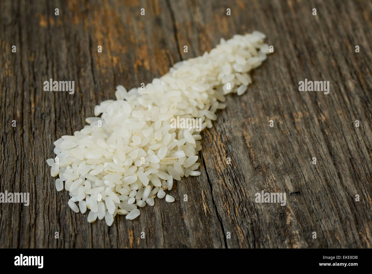 Rice isolated on a wood texture Stock Photo - Alamy