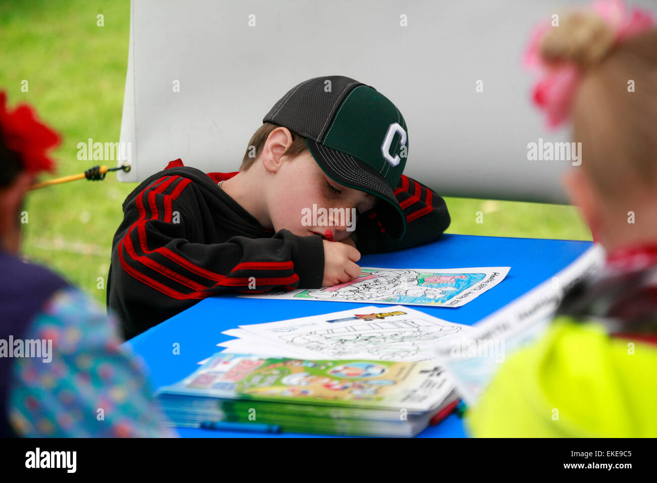 A young boy concentrates on coloring a page during an AFTERS School ...