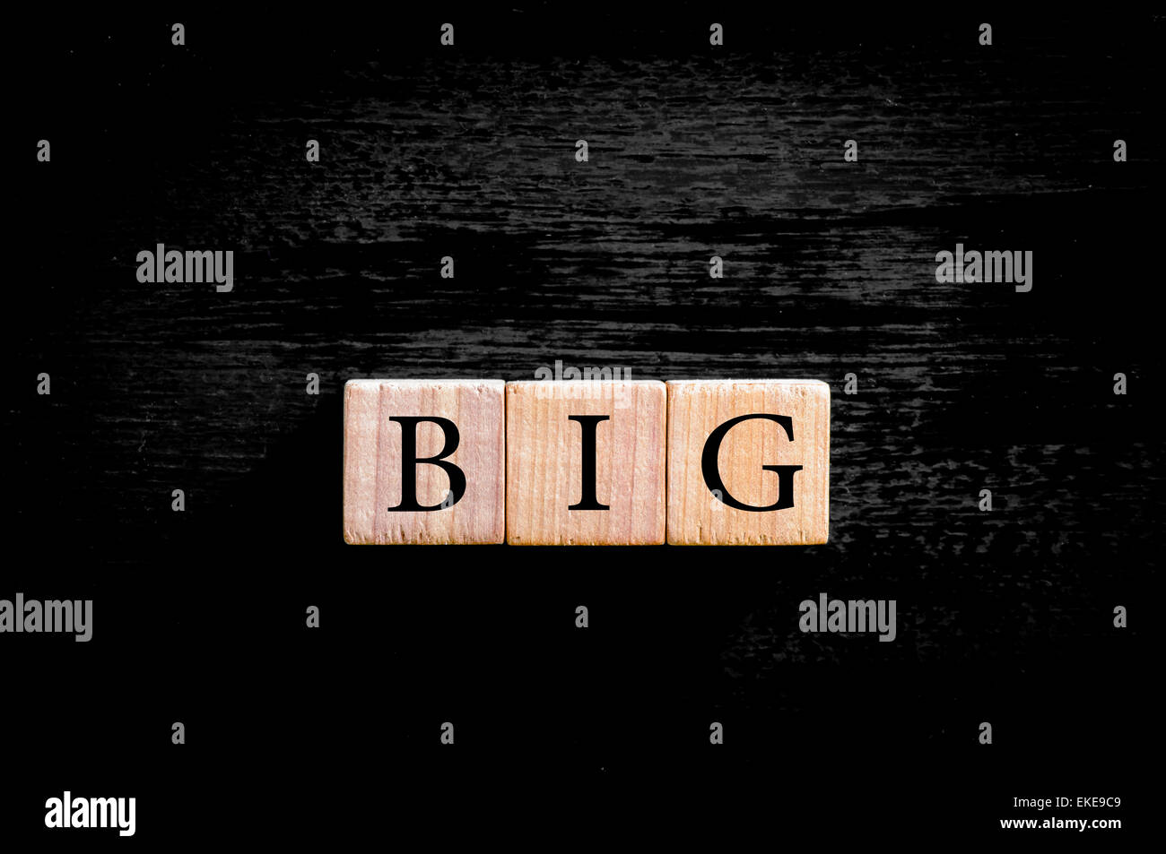 Word BIG. Wooden small cubes with letters isolated on black background ...