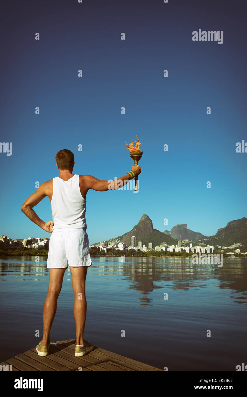 Young athletic man standing with Olympic sport torch against Rio de ...