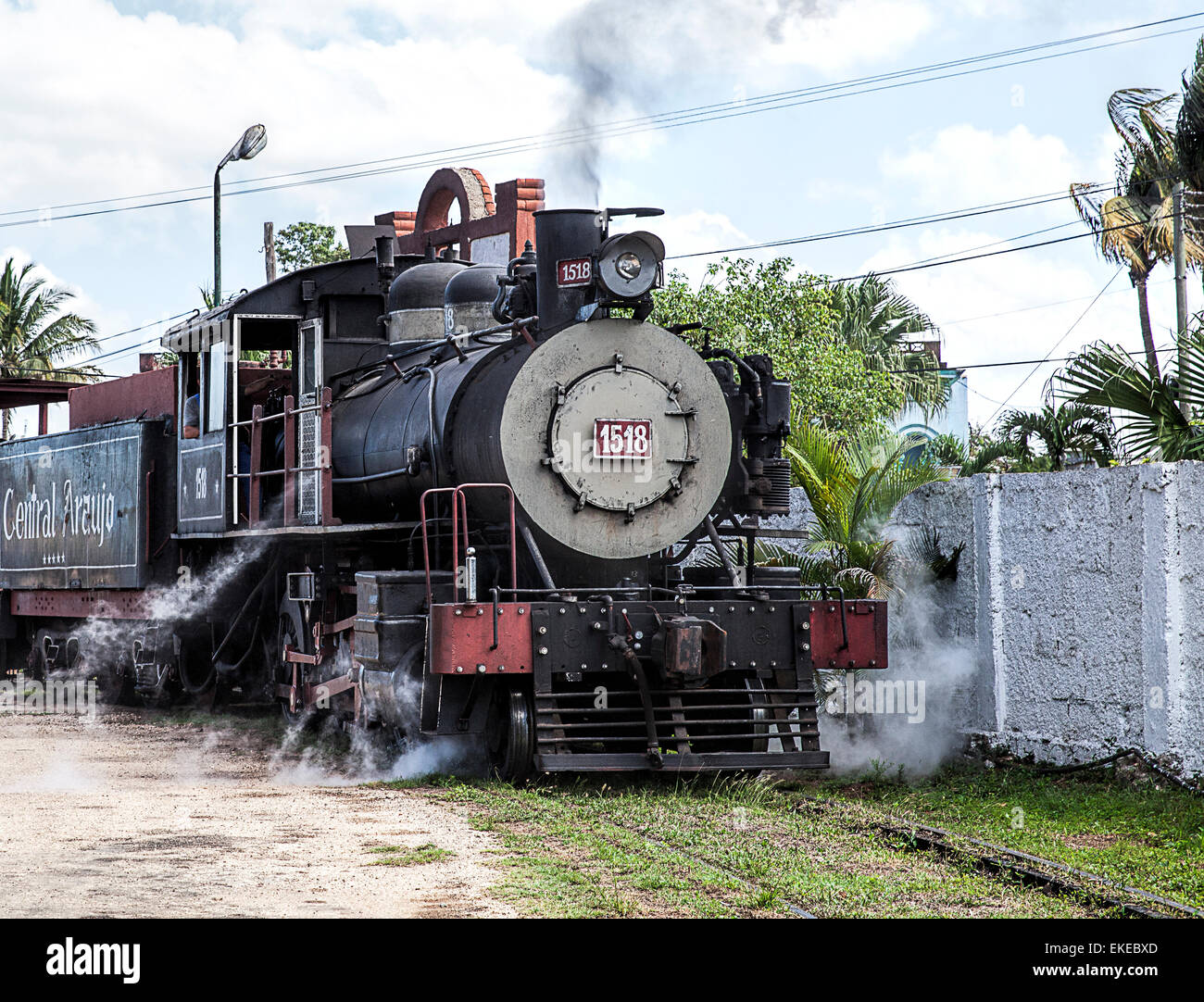 Old American steam engine with smoke and steam travelling along a ...