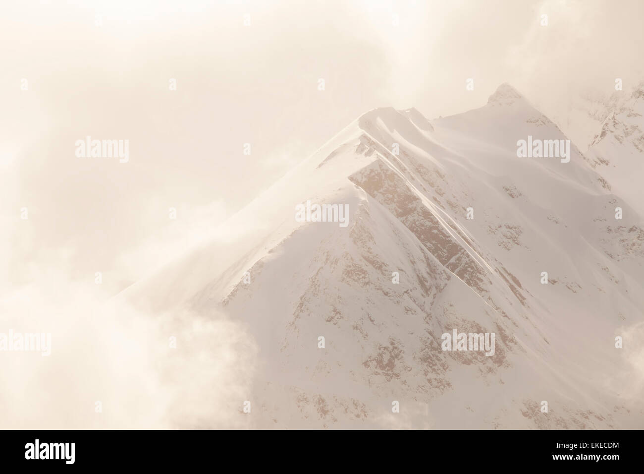 Alaskan mountain ridge in winter with snow in fog and low clouds Stock ...