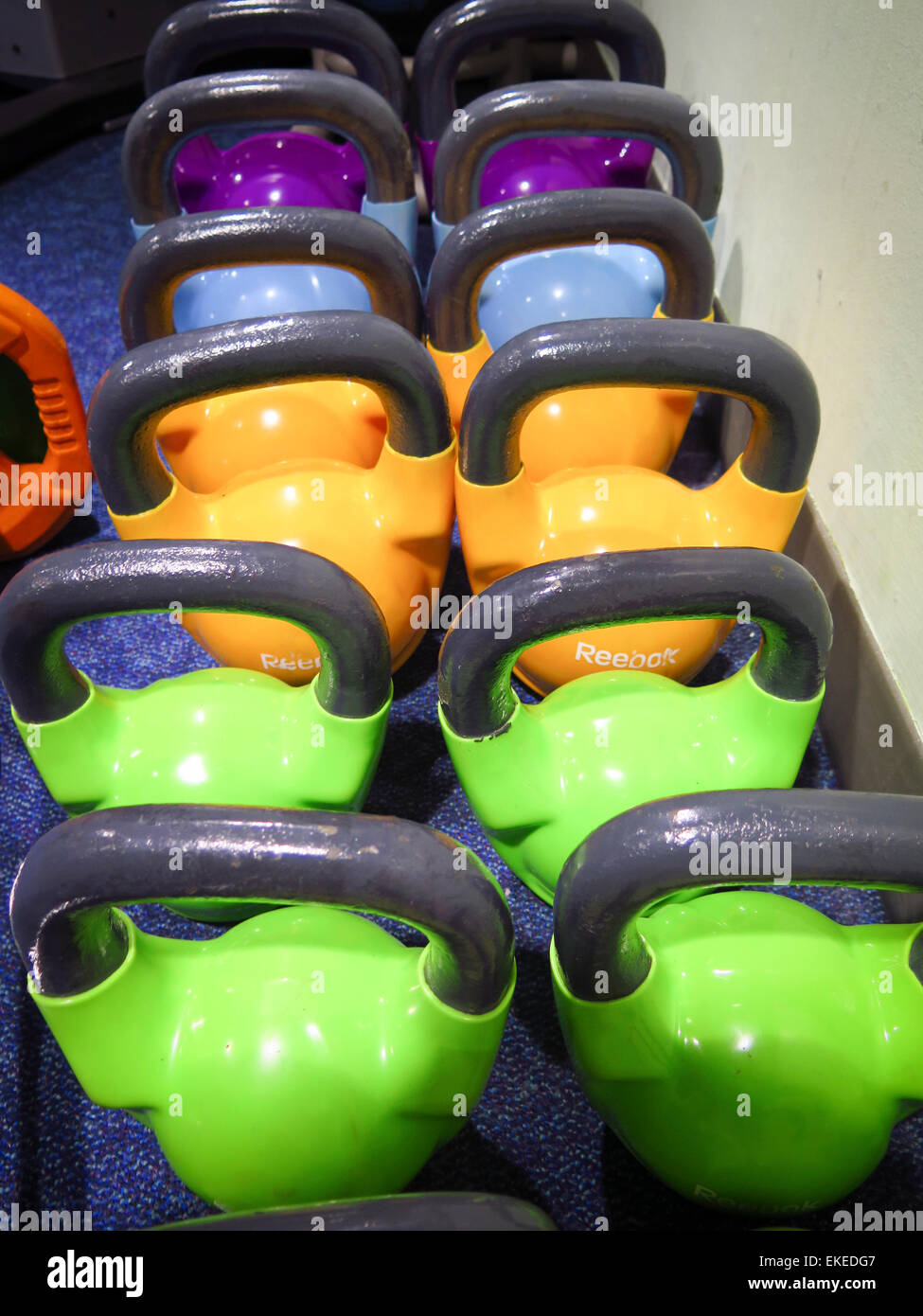 Brightly coloured kettle weights lined up in gym Stock Photo - Alamy