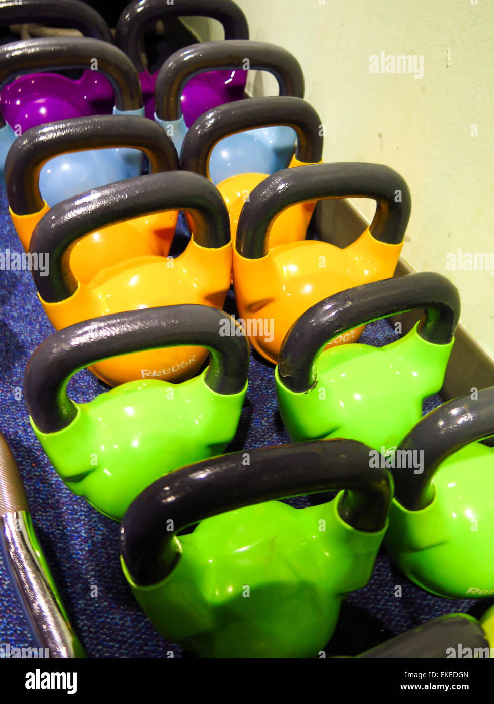 Brightly coloured kettle weights lined up in gym Stock Photo - Alamy