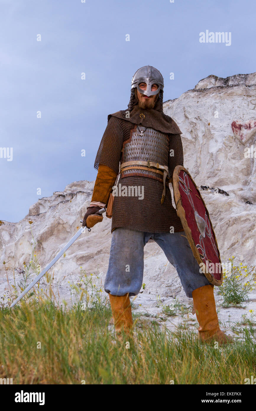 Knight on a rock with a sword against blue cloudy sky Stock Photo - Alamy