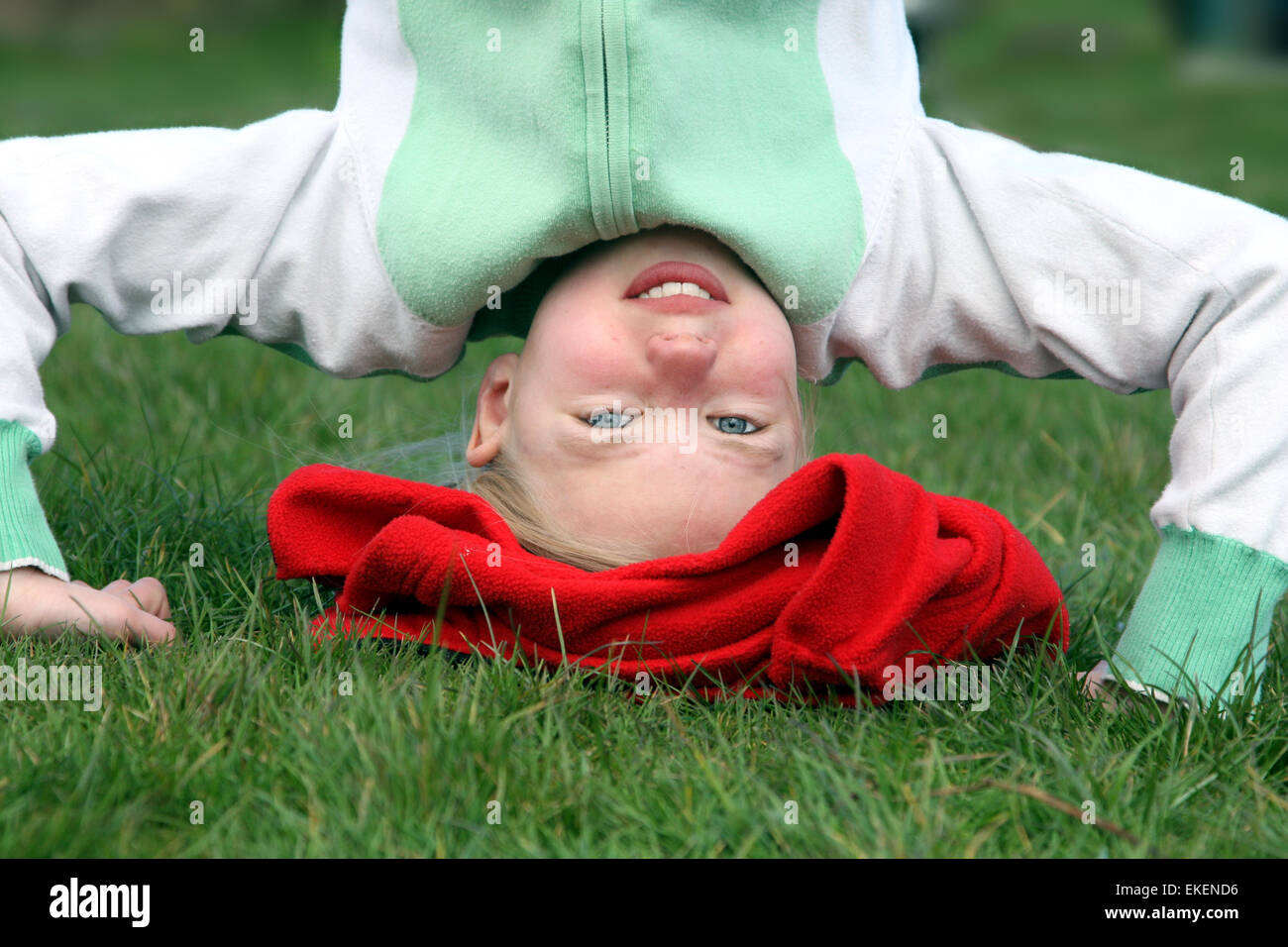 child playing, having head down in the grass Stock Photo - Alamy