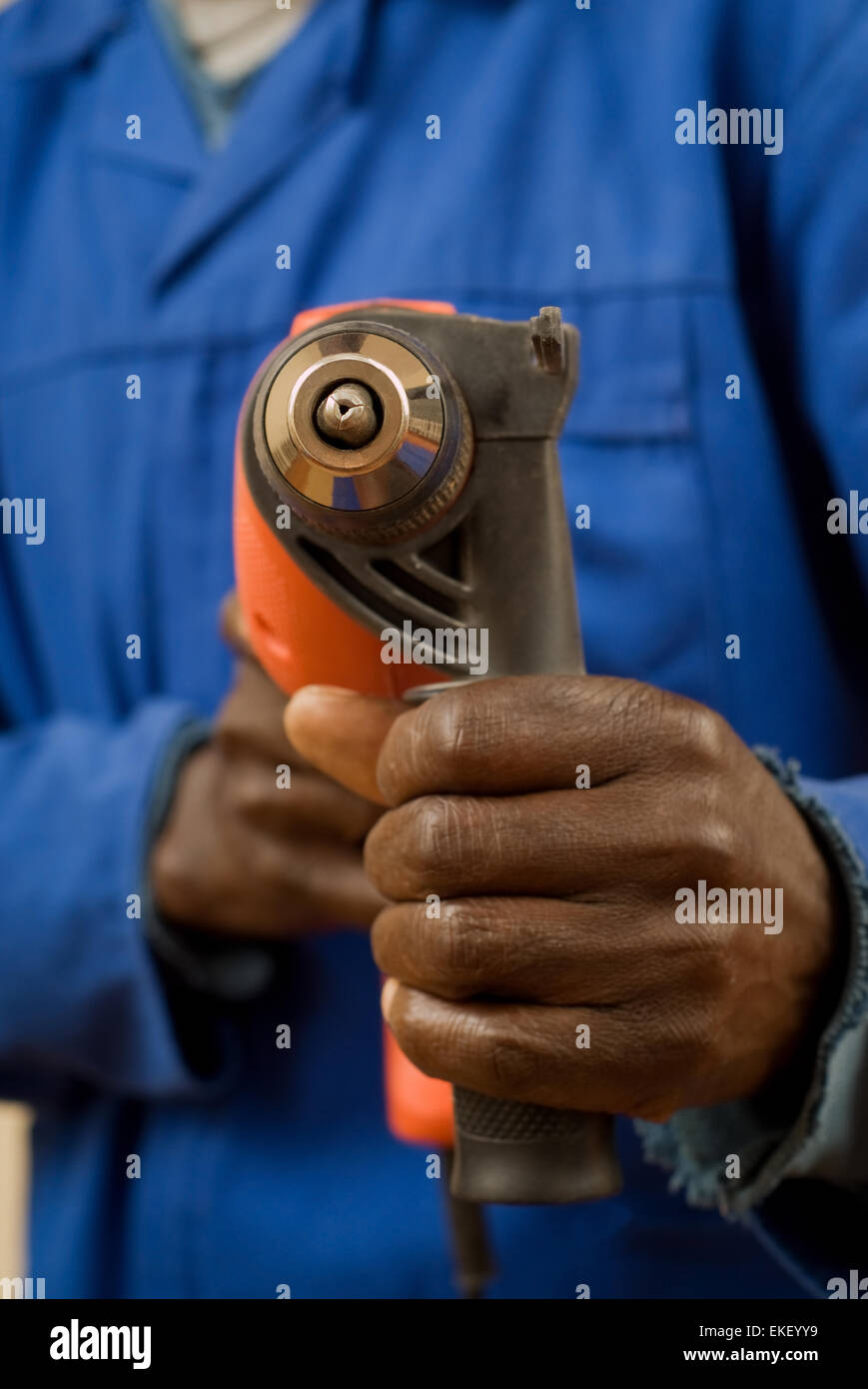 Construction worker holding a power tool Stock Photo - Alamy