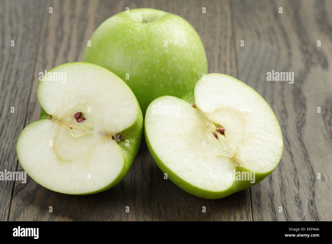 green sour apple on wood table sliced Stock Photo - Alamy