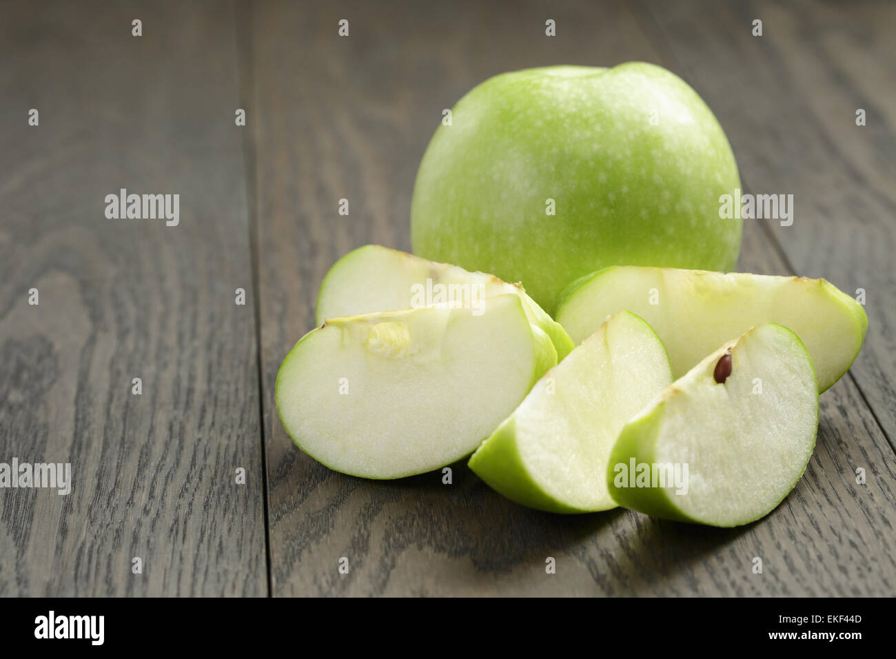 green sour apple on wood table sliced Stock Photo - Alamy