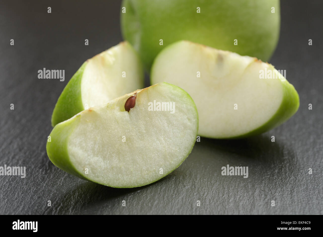 green sour apple on slate board sliced Stock Photo - Alamy