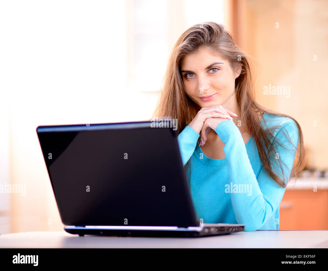 Portrait of a beautiful young lady working with laptop in the ki Stock ...