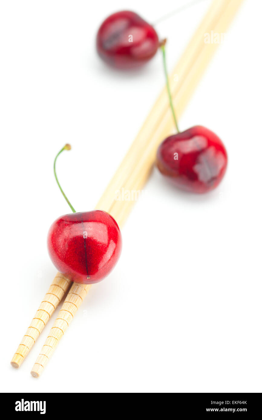 cherry and chopsticks isolated on white Stock Photo - Alamy