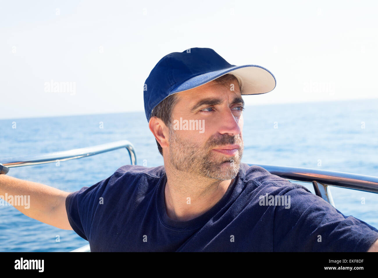 Sailor man at boat bow with cap looking away the sea Stock Photo - Alamy