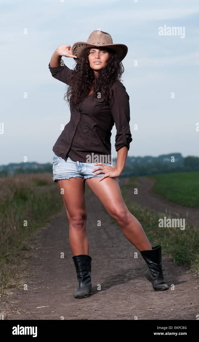 Beautiful cowboy woman posing in field Stock Photo - Alamy