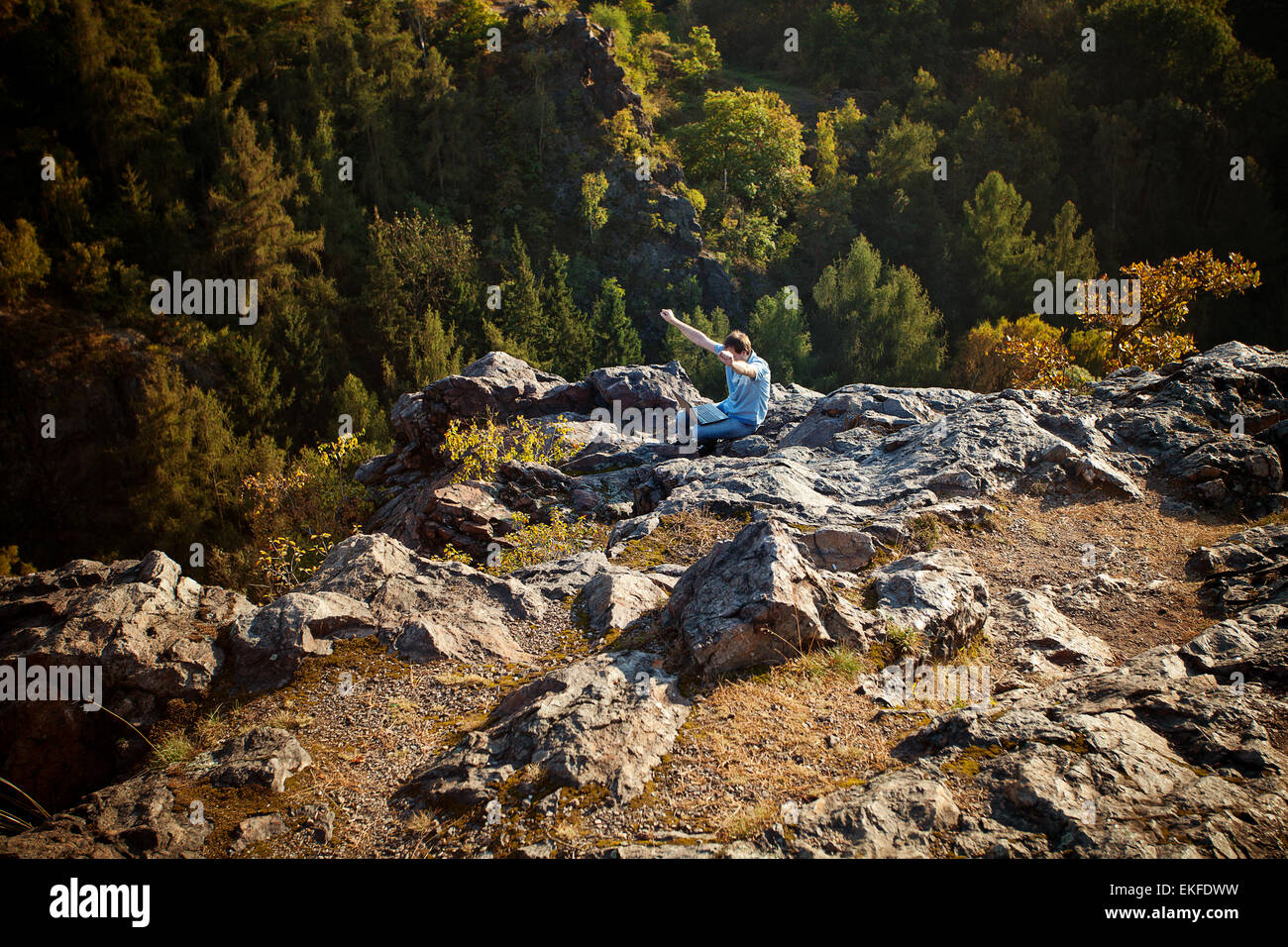 young man using laptop sitting on a rock slope Stock Photo - Alamy
