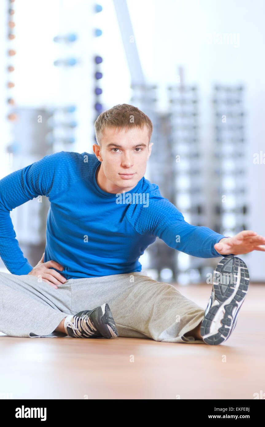Man doing stretching exercises at the gym Stock Photo - Alamy