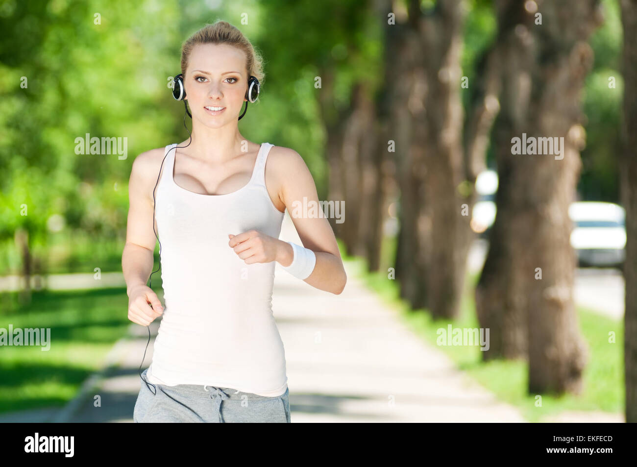 Young woman running in green park Stock Photo - Alamy