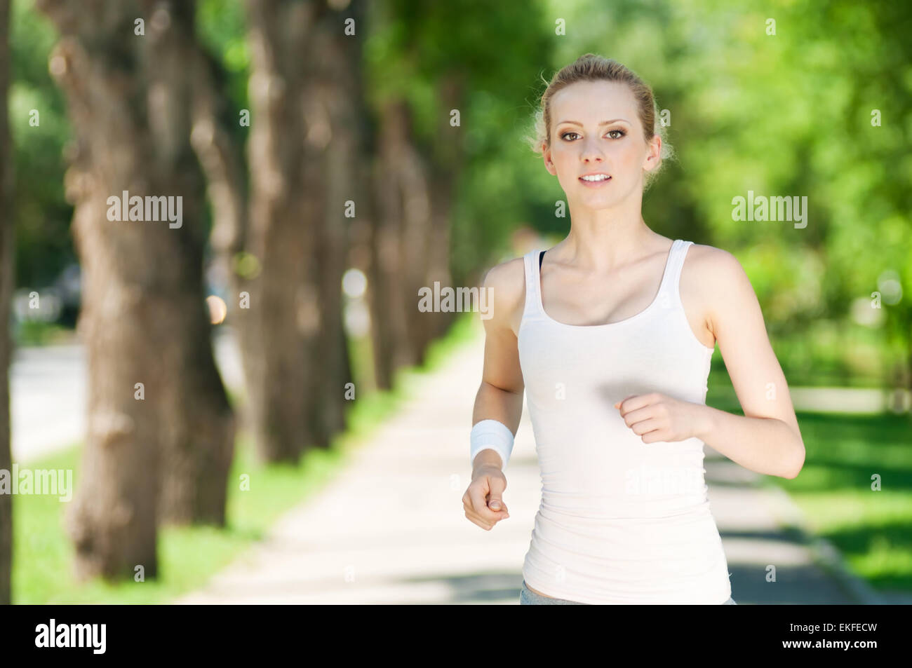Young woman running in green park Stock Photo - Alamy