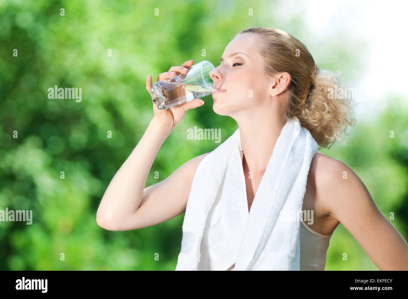 Woman drinking water after exercise Stock Photo - Alamy
