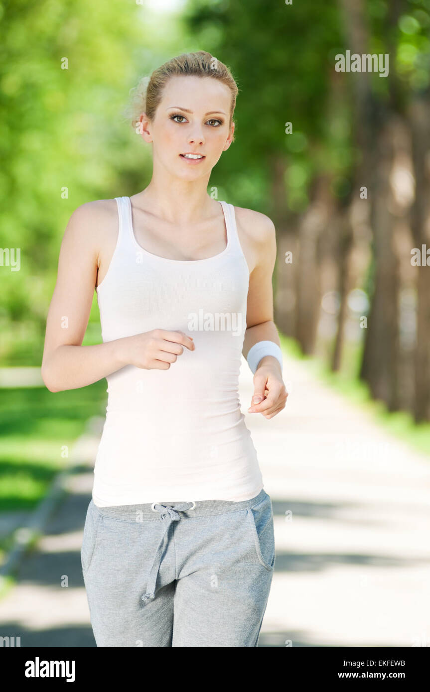 Young woman running in green park Stock Photo - Alamy