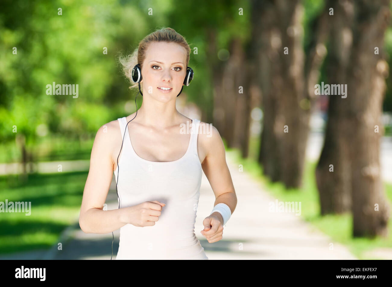 Young woman running in green park Stock Photo - Alamy