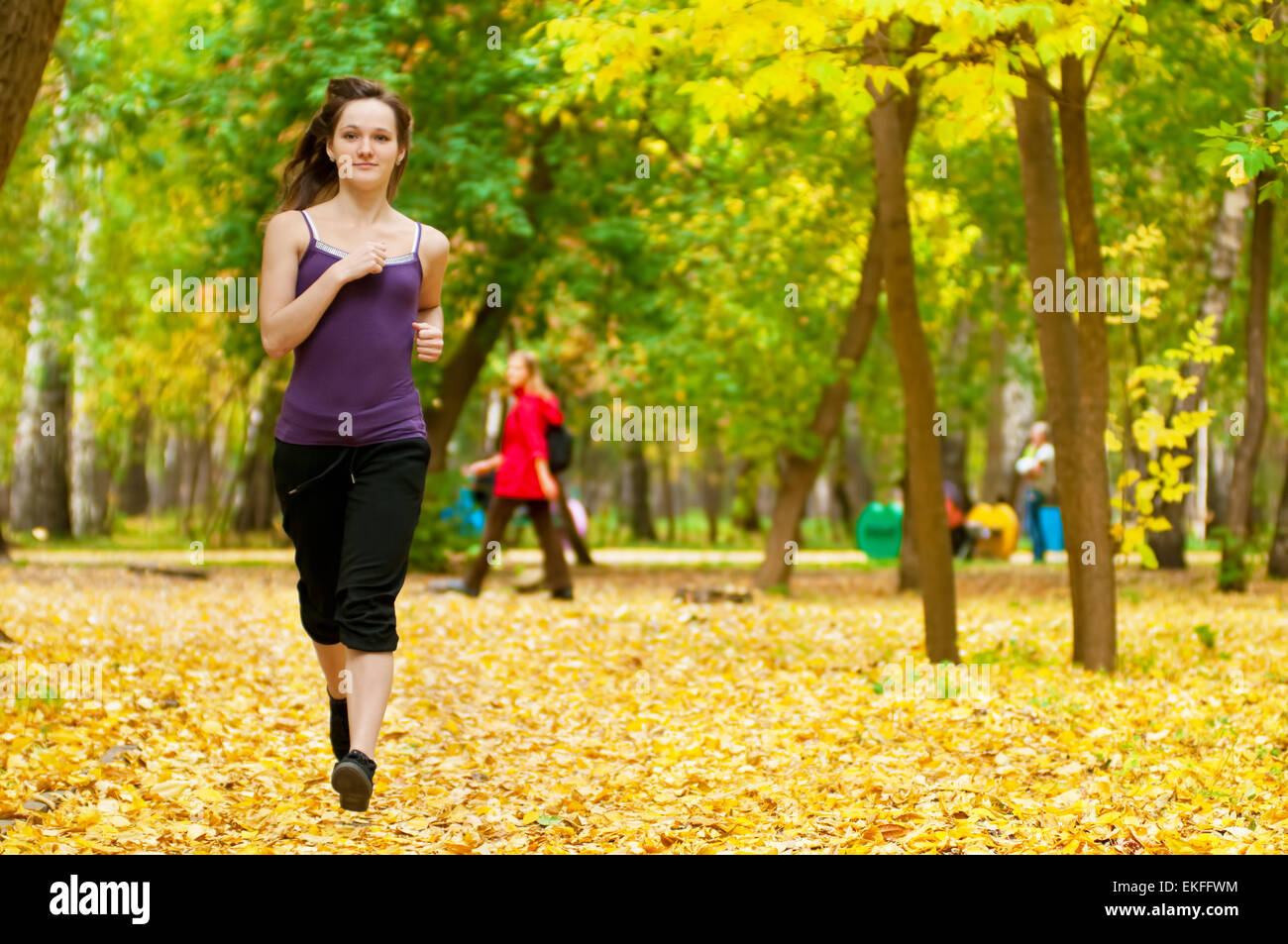 A young girl running in autumn park Stock Photo - Alamy