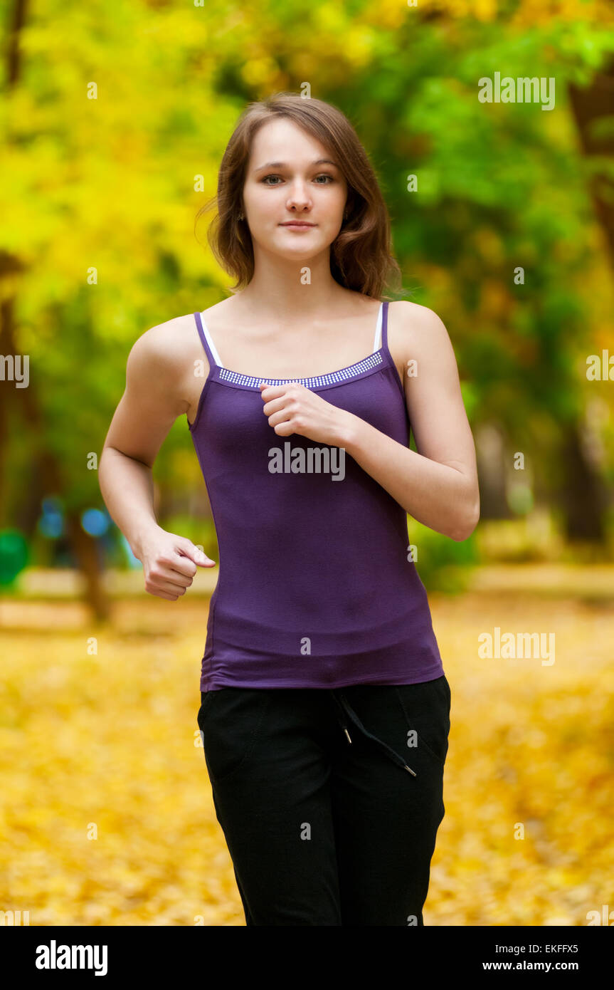 A young girl running in autumn park Stock Photo - Alamy