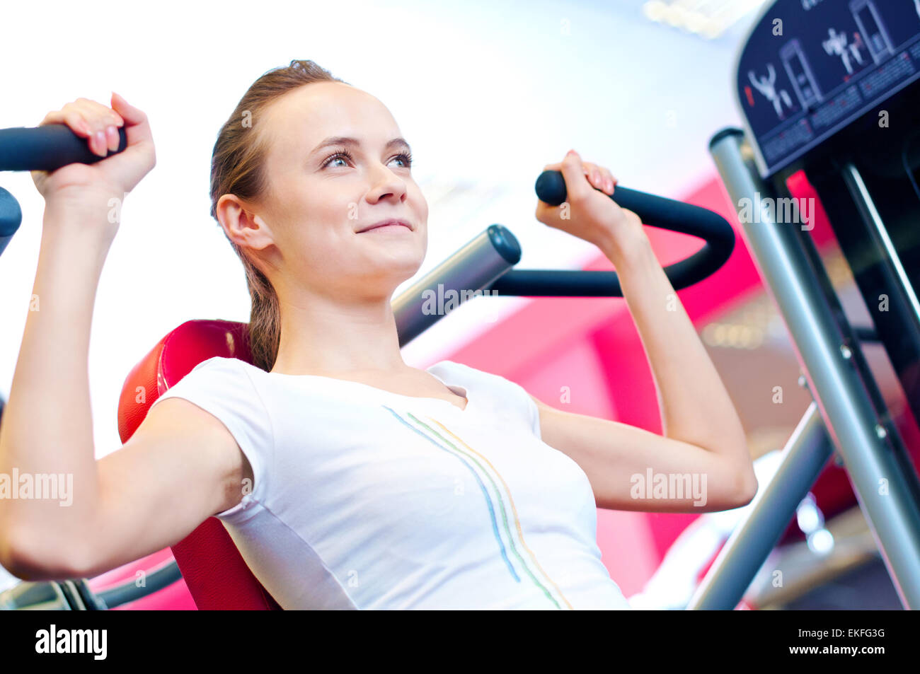 Woman doing splits on machine with weights Stock Photo - Alamy