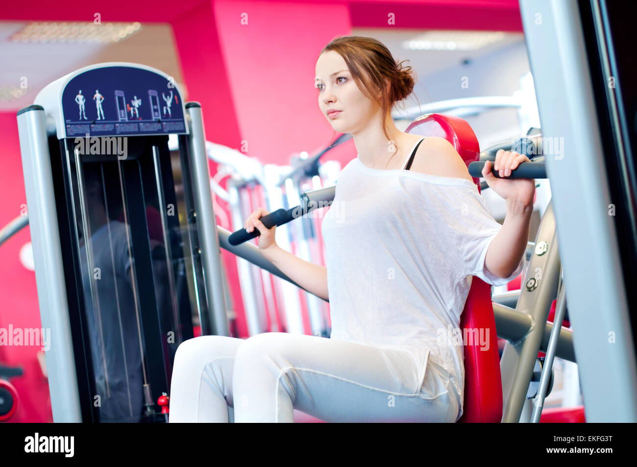 Woman doing splits on machine with weights Stock Photo - Alamy