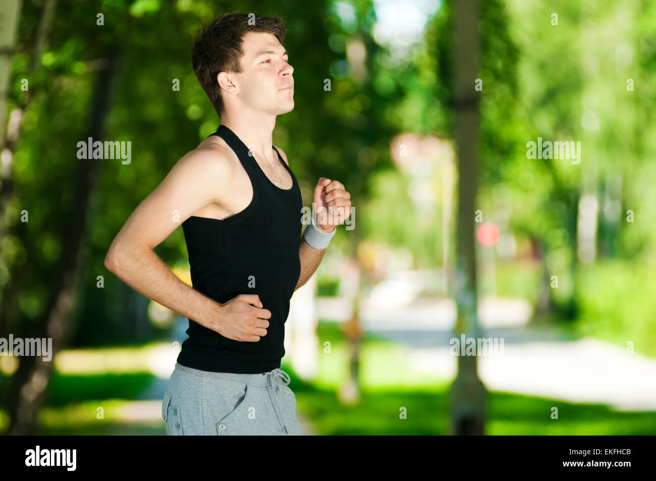 Young man jogging in park Stock Photo - Alamy