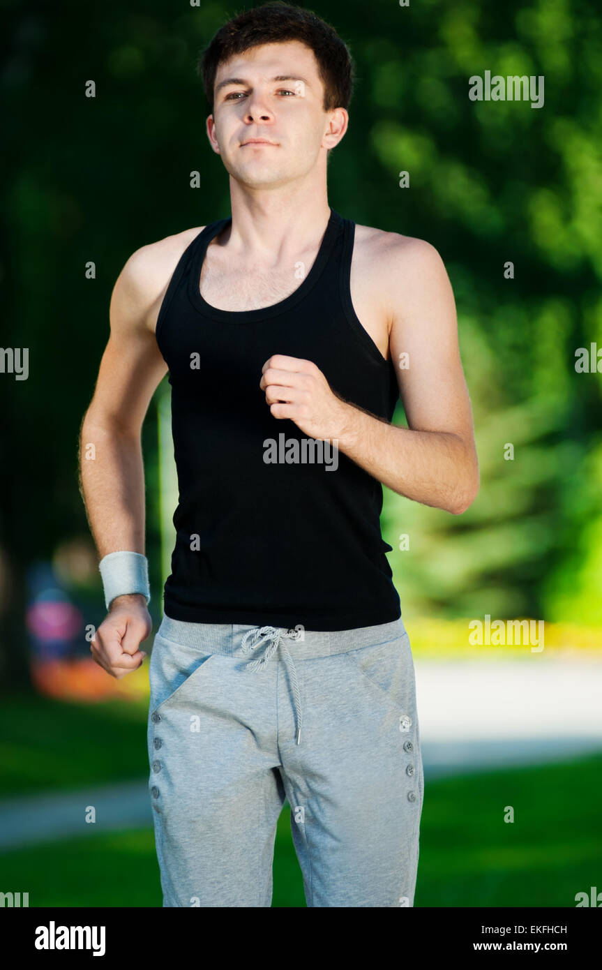 Young man jogging in park Stock Photo - Alamy