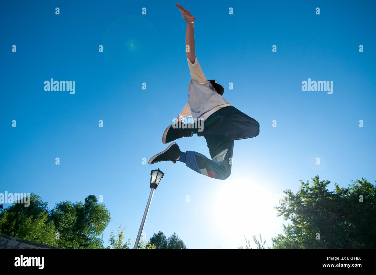 Men jump over blue sky Stock Photo - Alamy