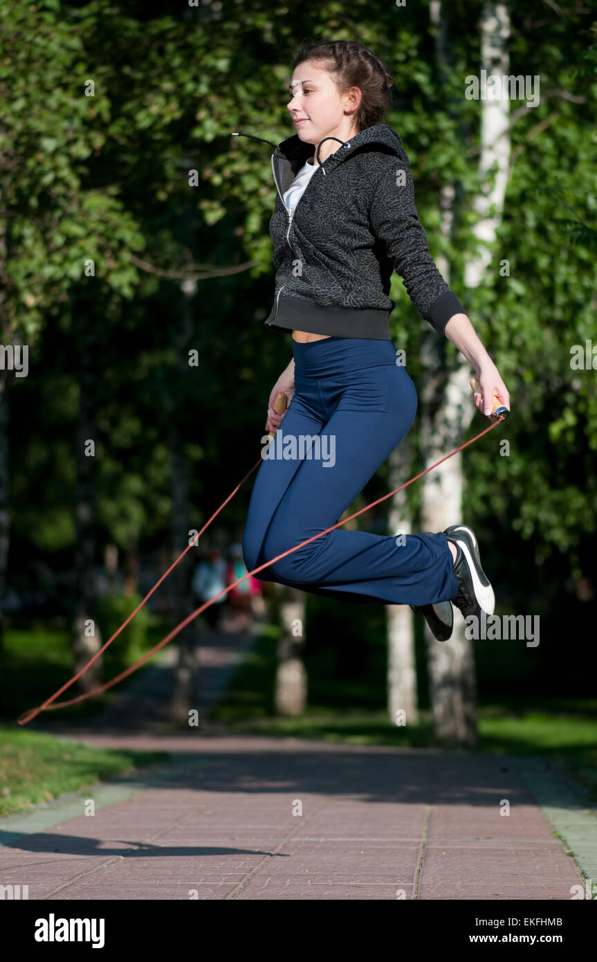 Jumping woman with skipping rope at park Stock Photo - Alamy