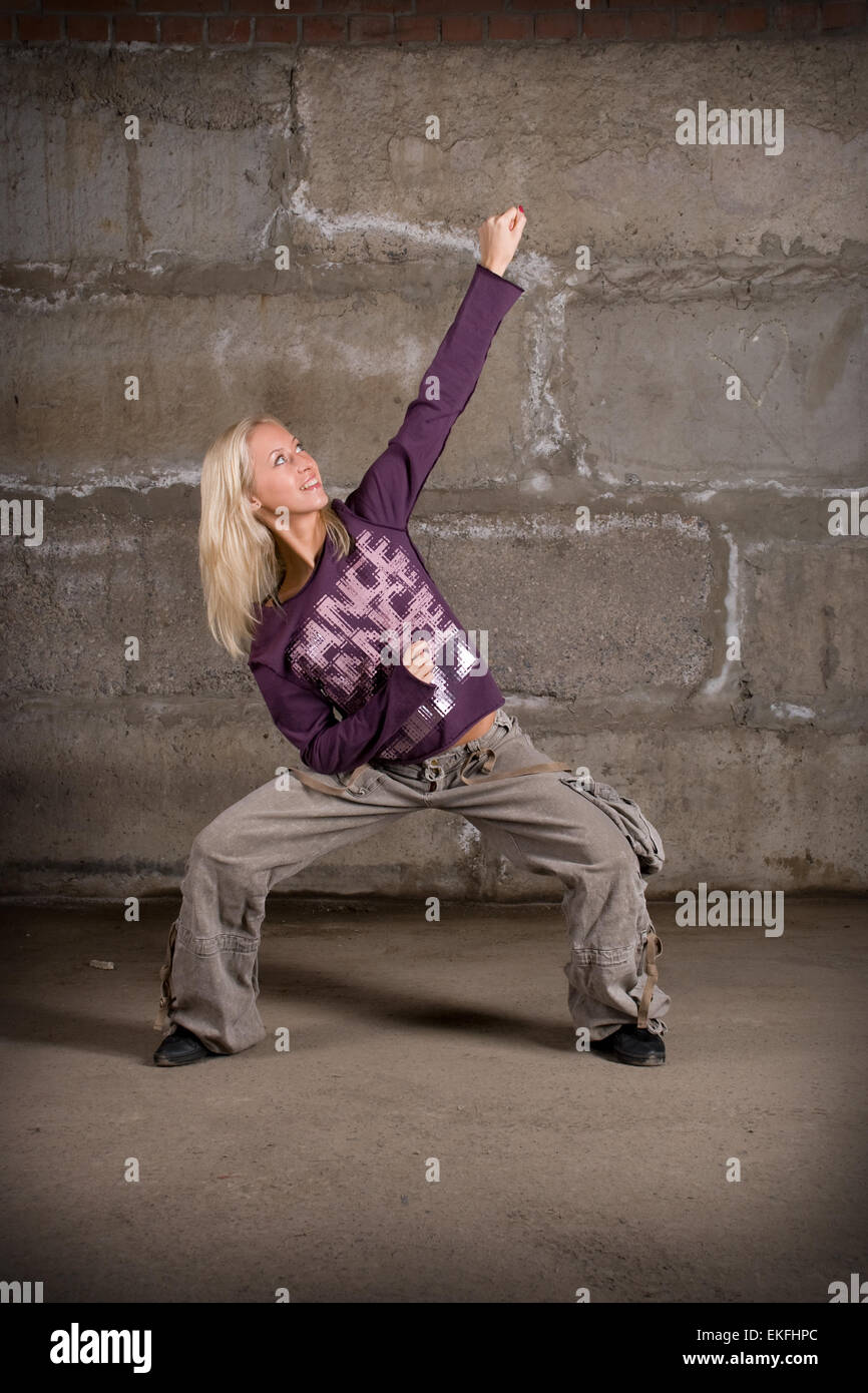 Beautiful hip hop girl dancing over grey brick wall Stock Photo - Alamy