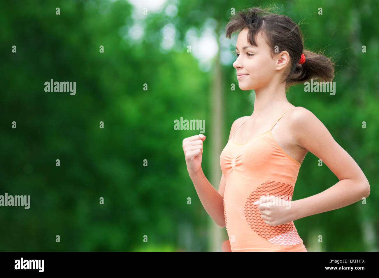 Teenage girl running in green park Stock Photo - Alamy