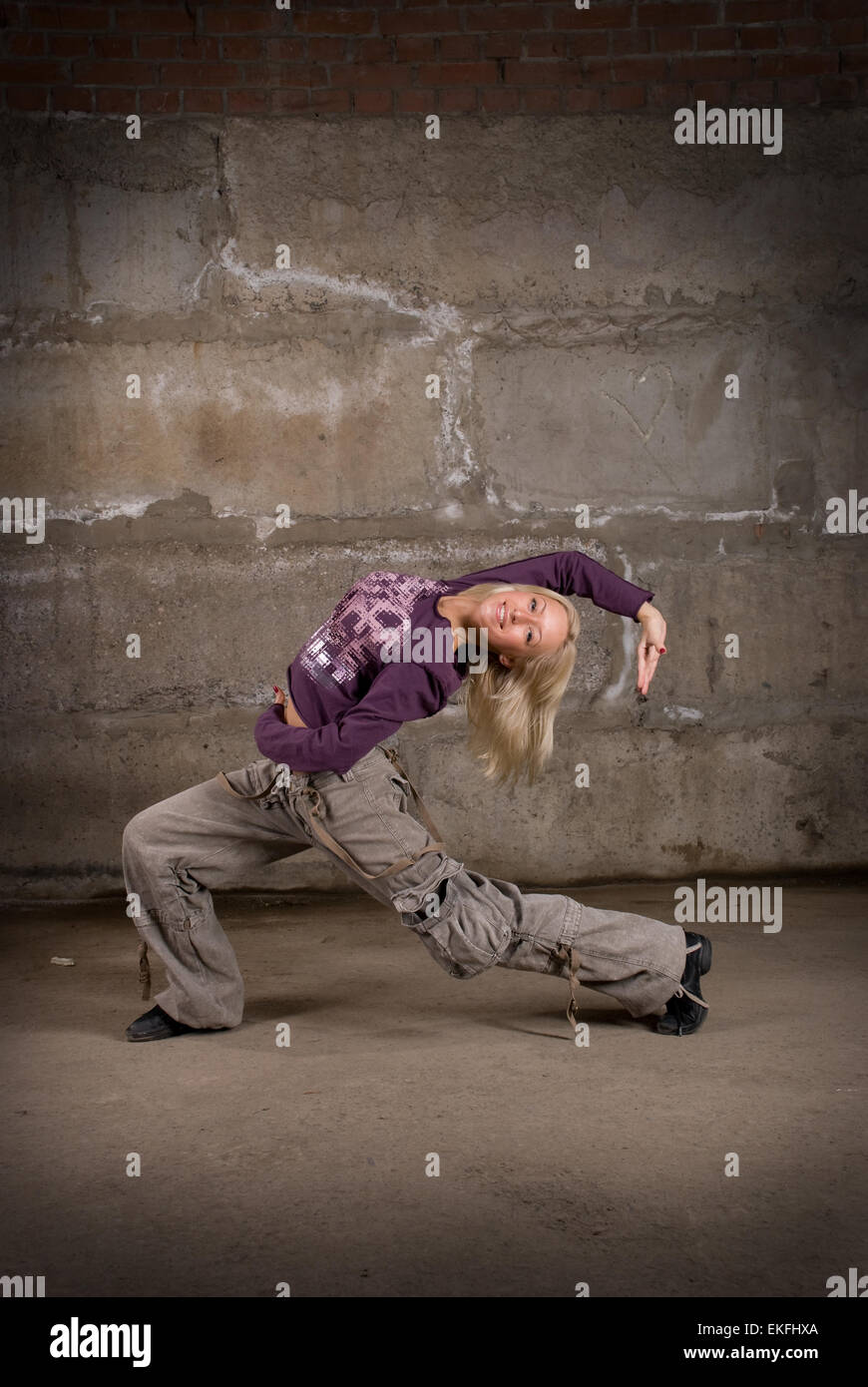 Beautiful hip hop girl dancing over grey brick wall Stock Photo - Alamy