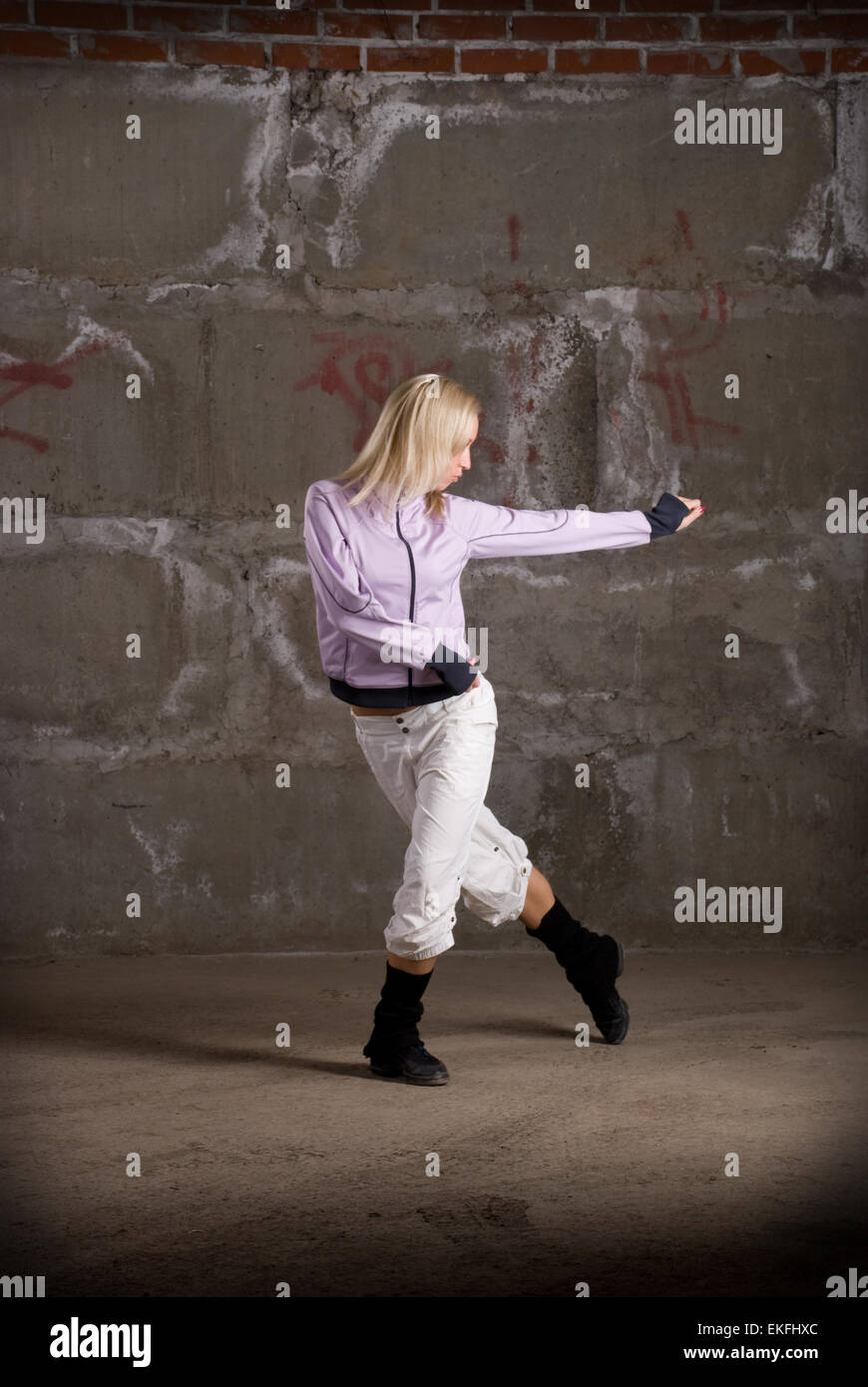 Beautiful hip hop girl dancing over grey brick wall Stock Photo - Alamy