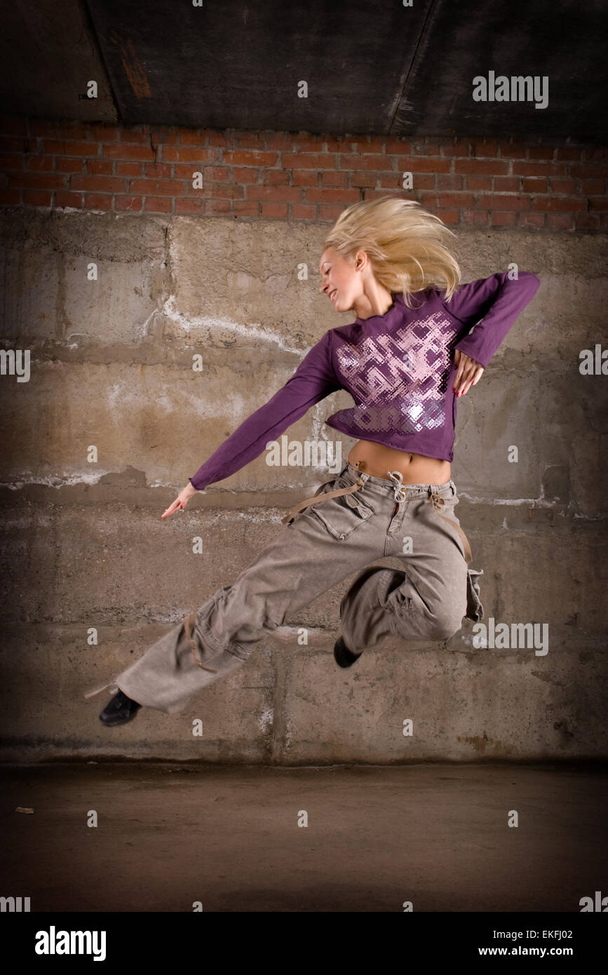 Beautiful hip hop girl dancing over grey brick wall Stock Photo - Alamy