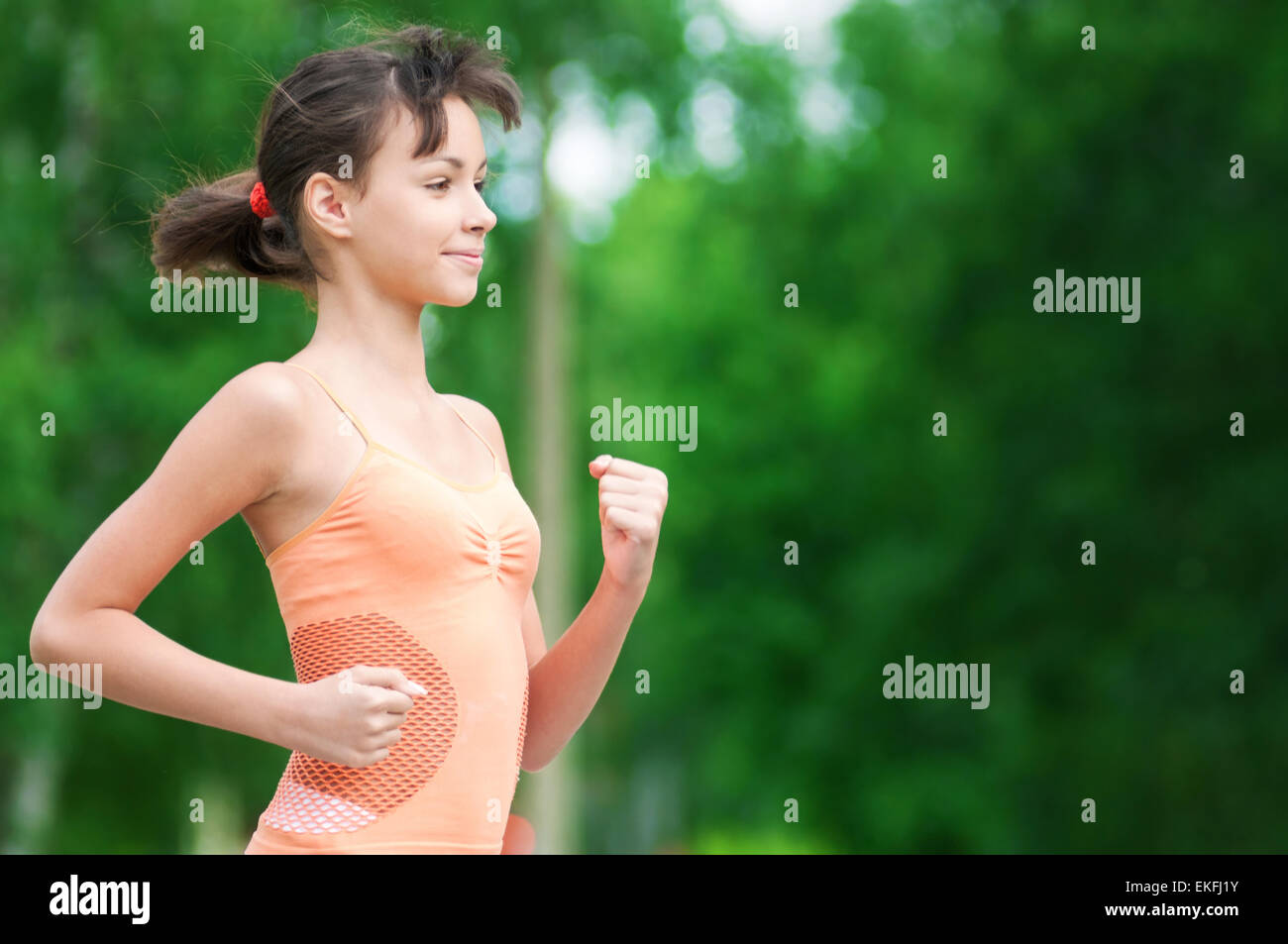 Teenage girl running in green park Stock Photo - Alamy