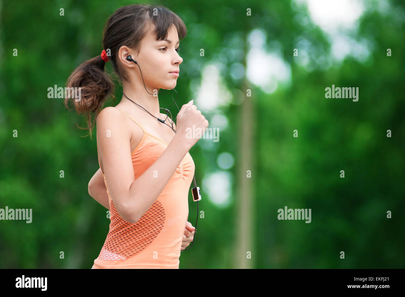 Teenage girl running in green park Stock Photo - Alamy