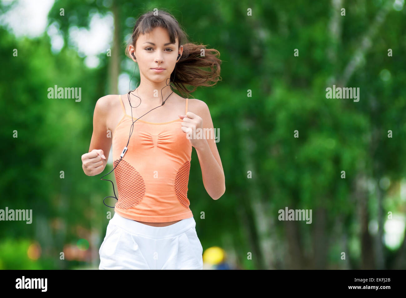 Teenage girl running in green park Stock Photo - Alamy