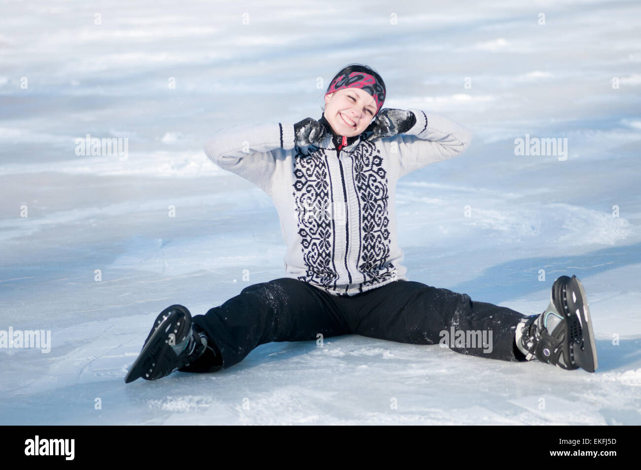 Ice skating woman sitting on ice Stock Photo - Alamy