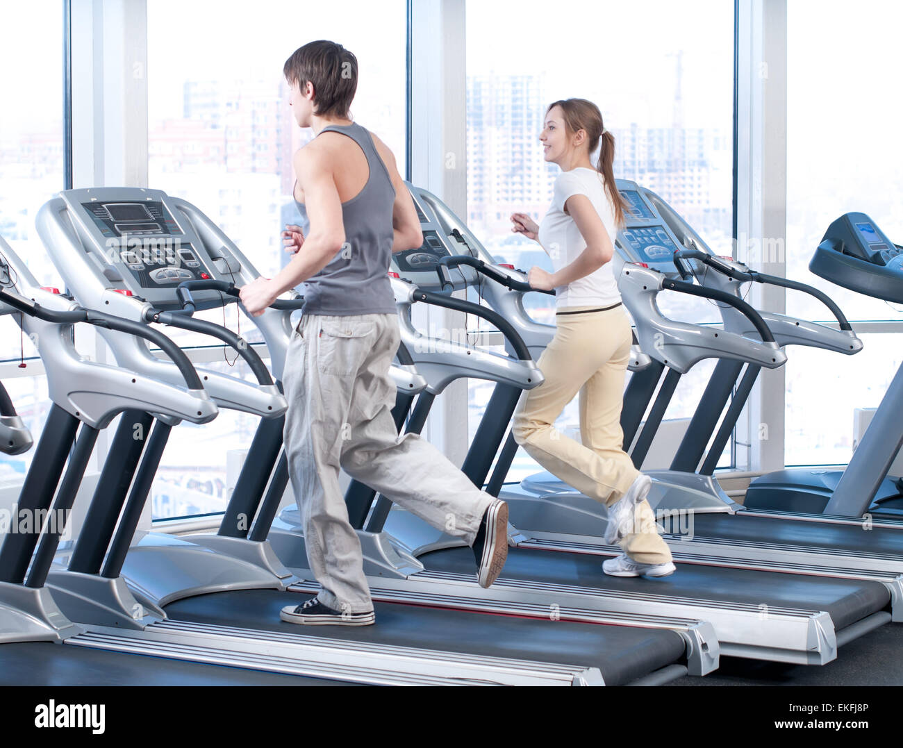 Young woman and man at the gym exercising. Running Stock Photo - Alamy