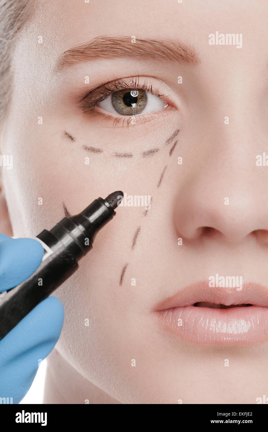 Beautician draw correction lines on woman face Stock Photo - Alamy