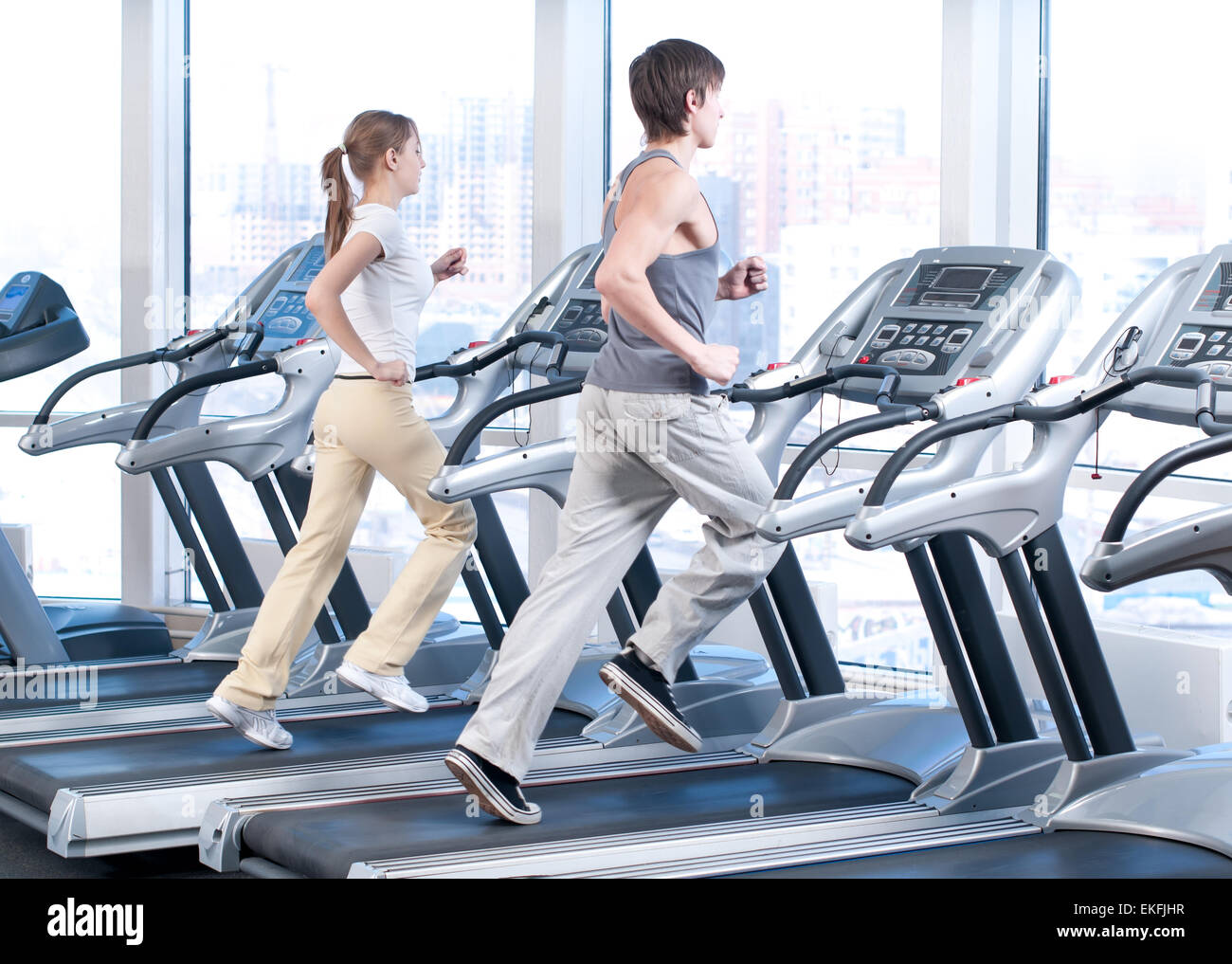 Young woman and man at the gym exercising. Running Stock Photo - Alamy