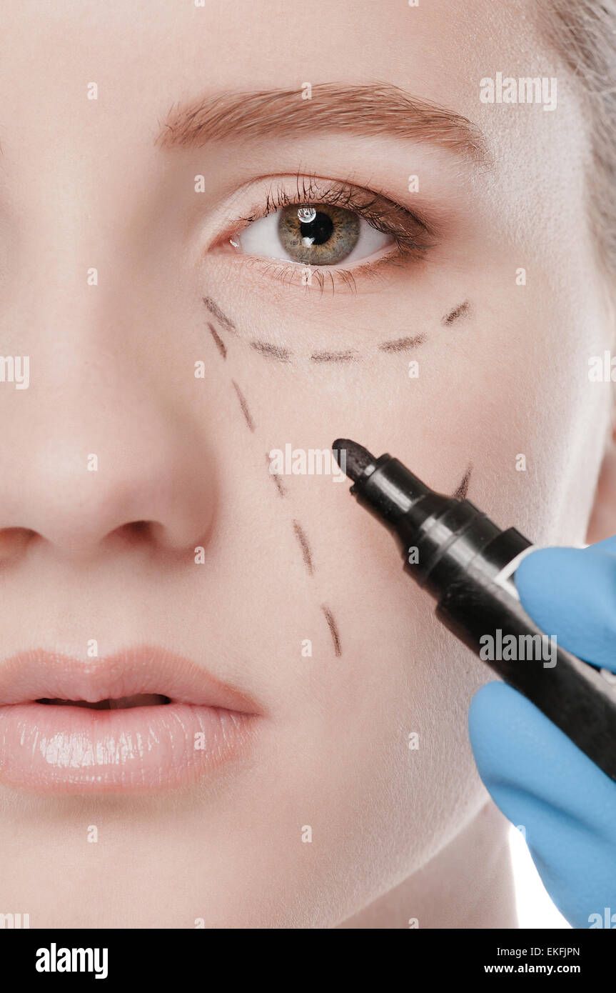 Beautician draw correction lines on woman face Stock Photo - Alamy