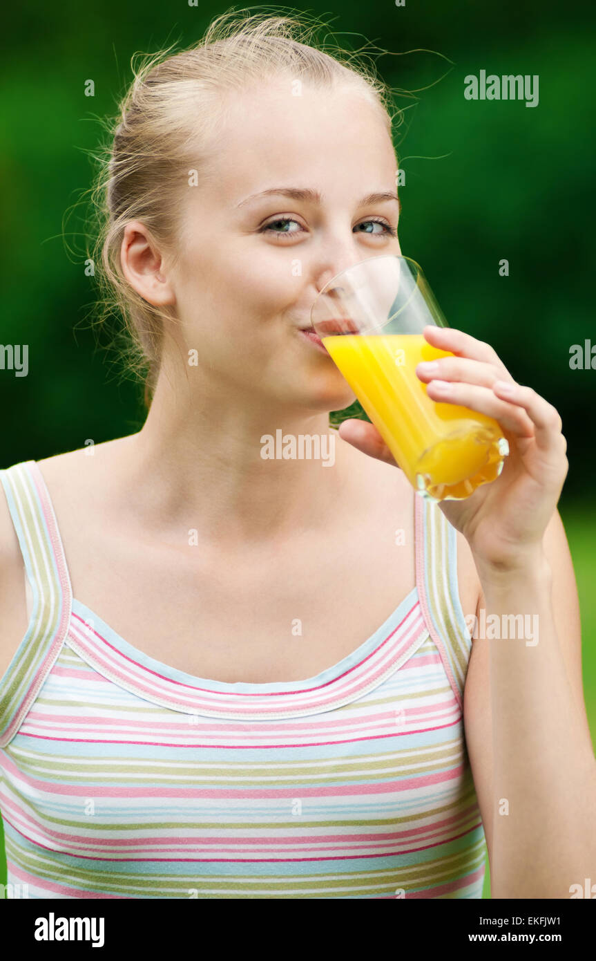 Young woman drinking orange juice. Outdoor Stock Photo - Alamy