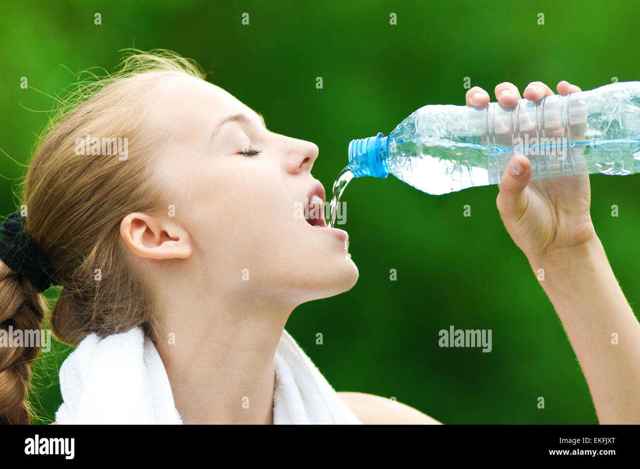 Woman drinking water after exercise Stock Photo - Alamy