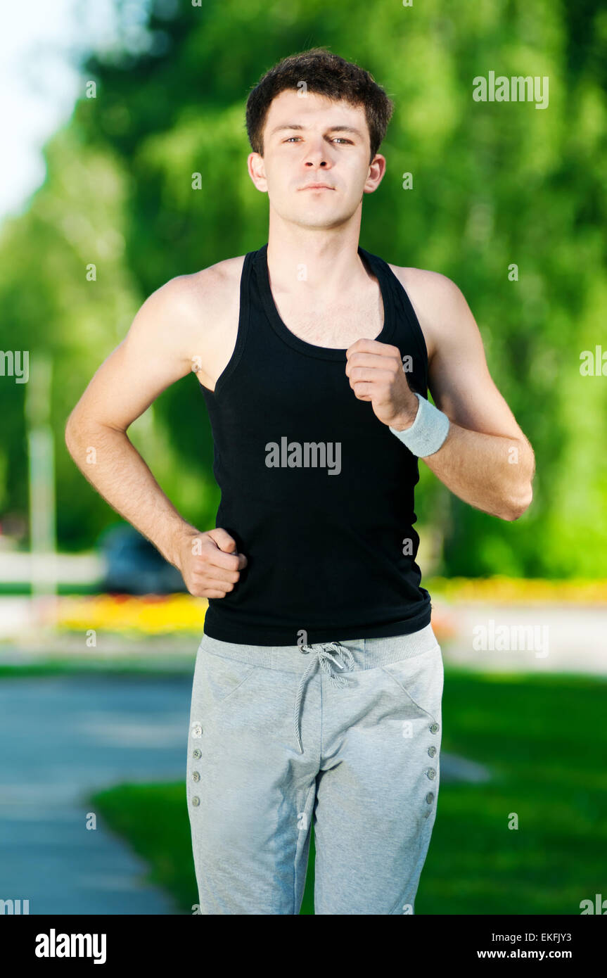 Young man jogging in park Stock Photo - Alamy