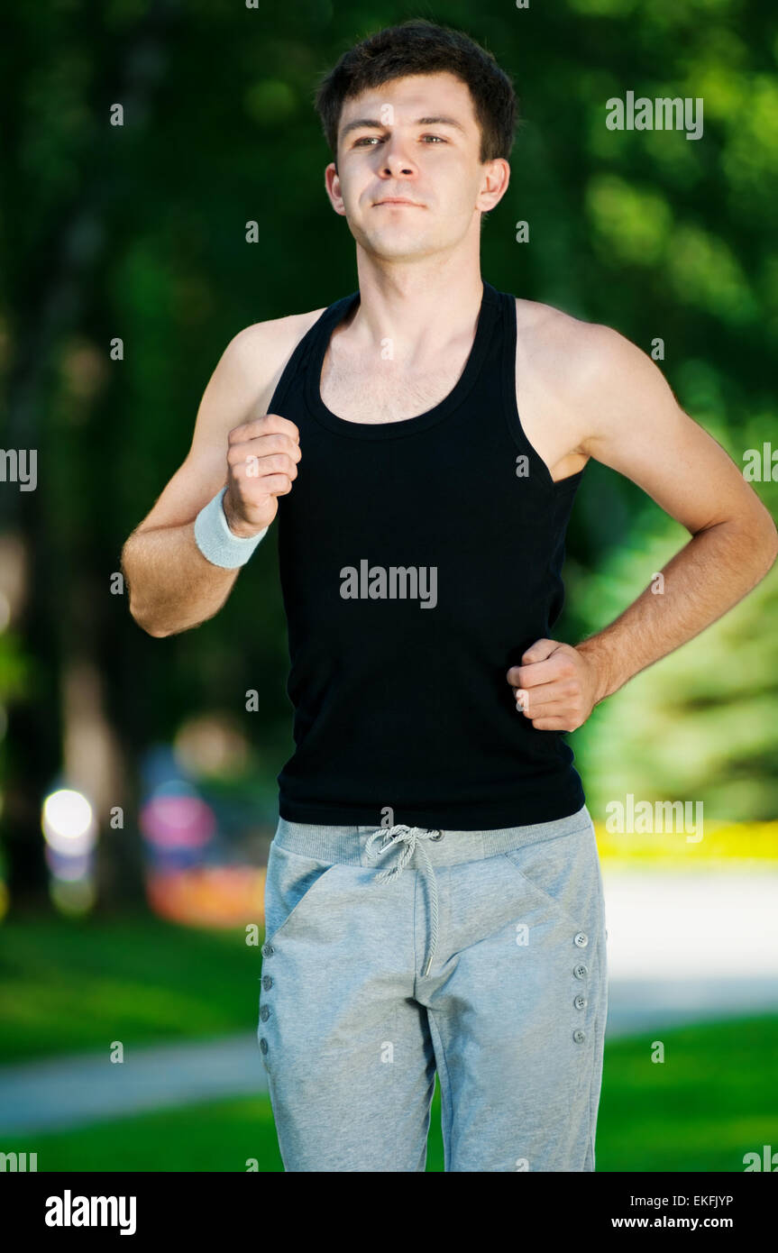 Young man jogging in park Stock Photo - Alamy